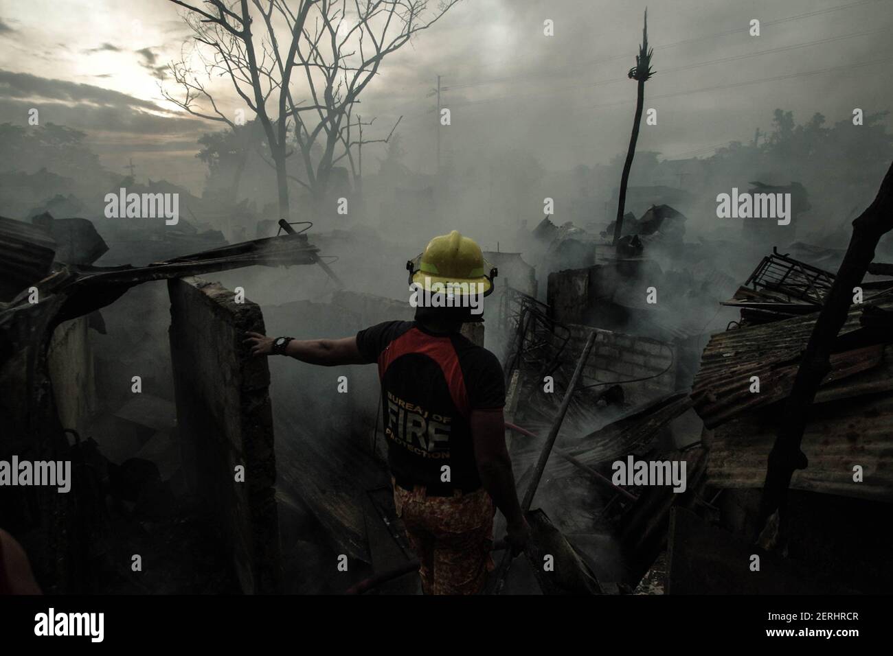 Fire volunteer inspects a residential area after a huge fire in F ...