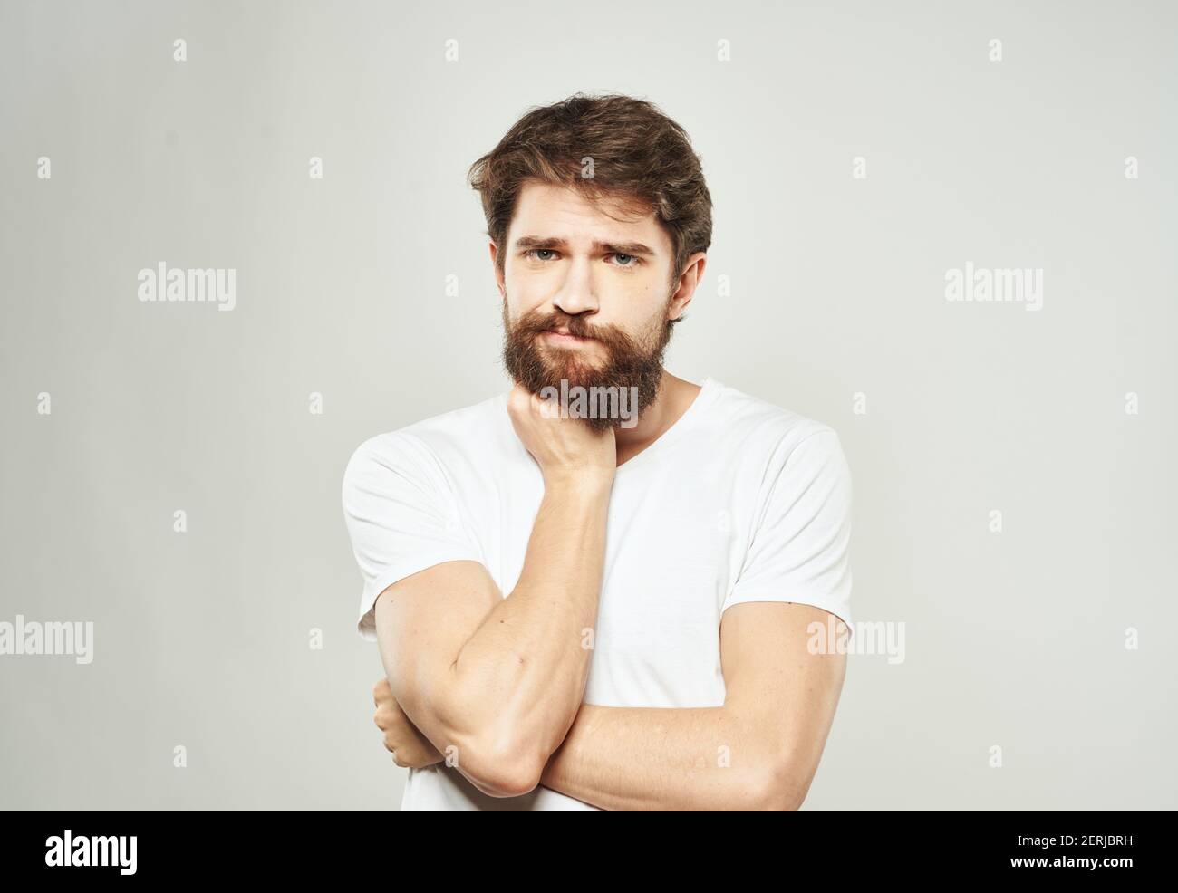 Man touches face with hands emotions model light background Stock Photo ...
