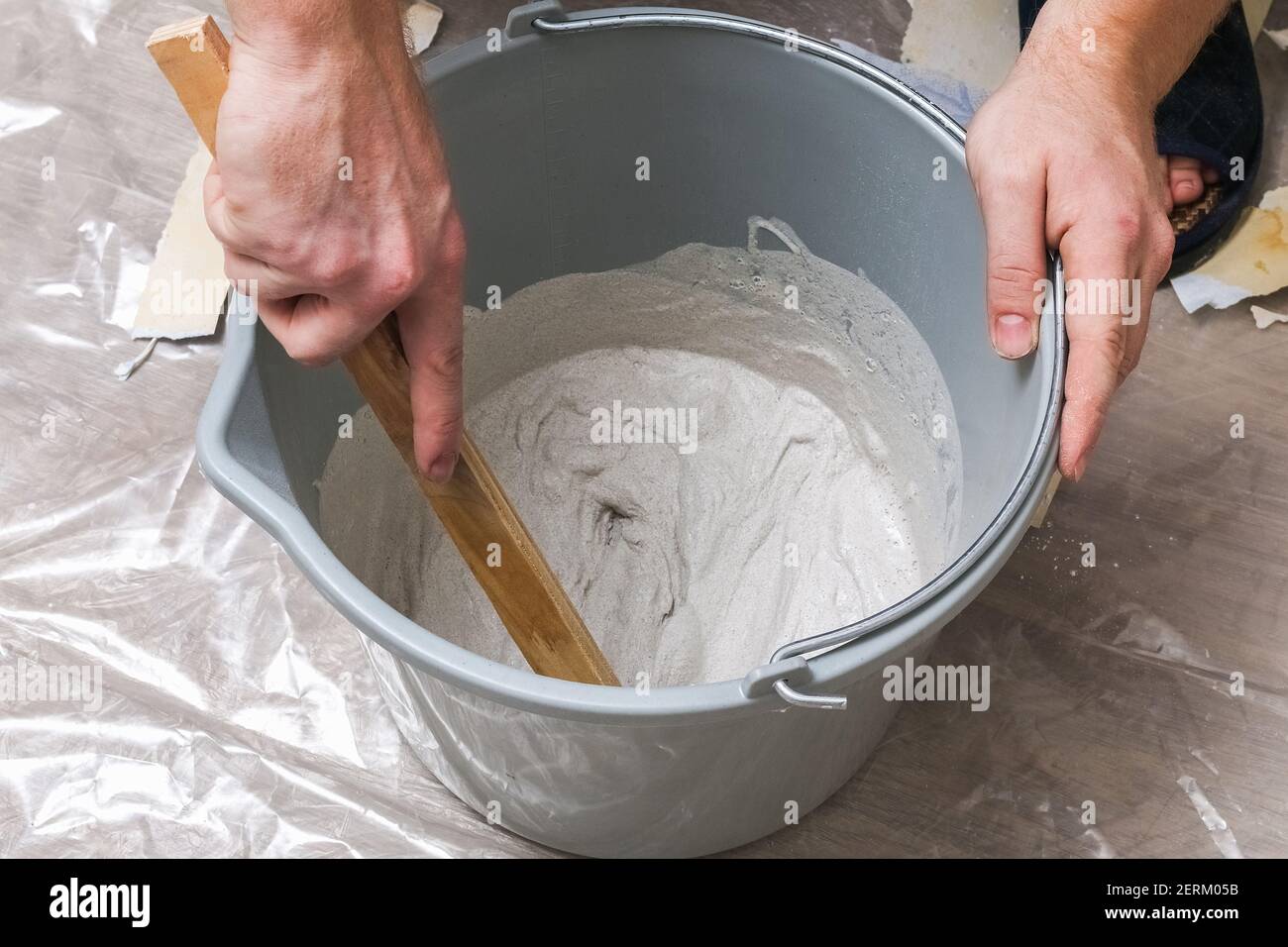 Mixing white plaster in a bucket with a stirrer. Close-up Stock Photo ...