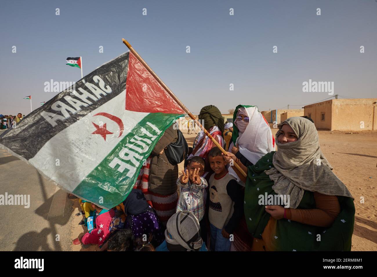 Sahrawis watch soldiers march in a parade during the celebrations ...