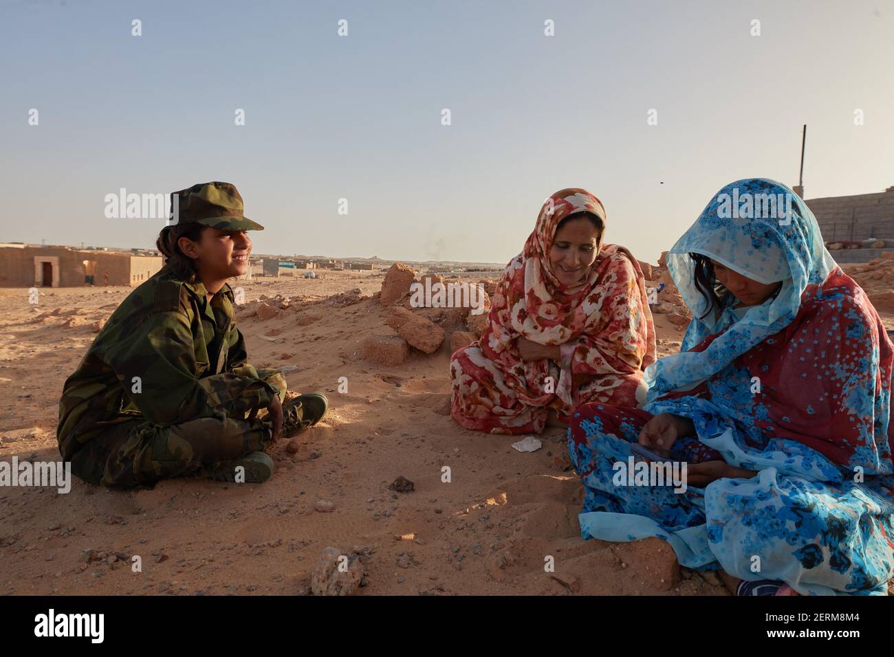 Sahrawis watch soldiers march in a parade during the celebrations ...