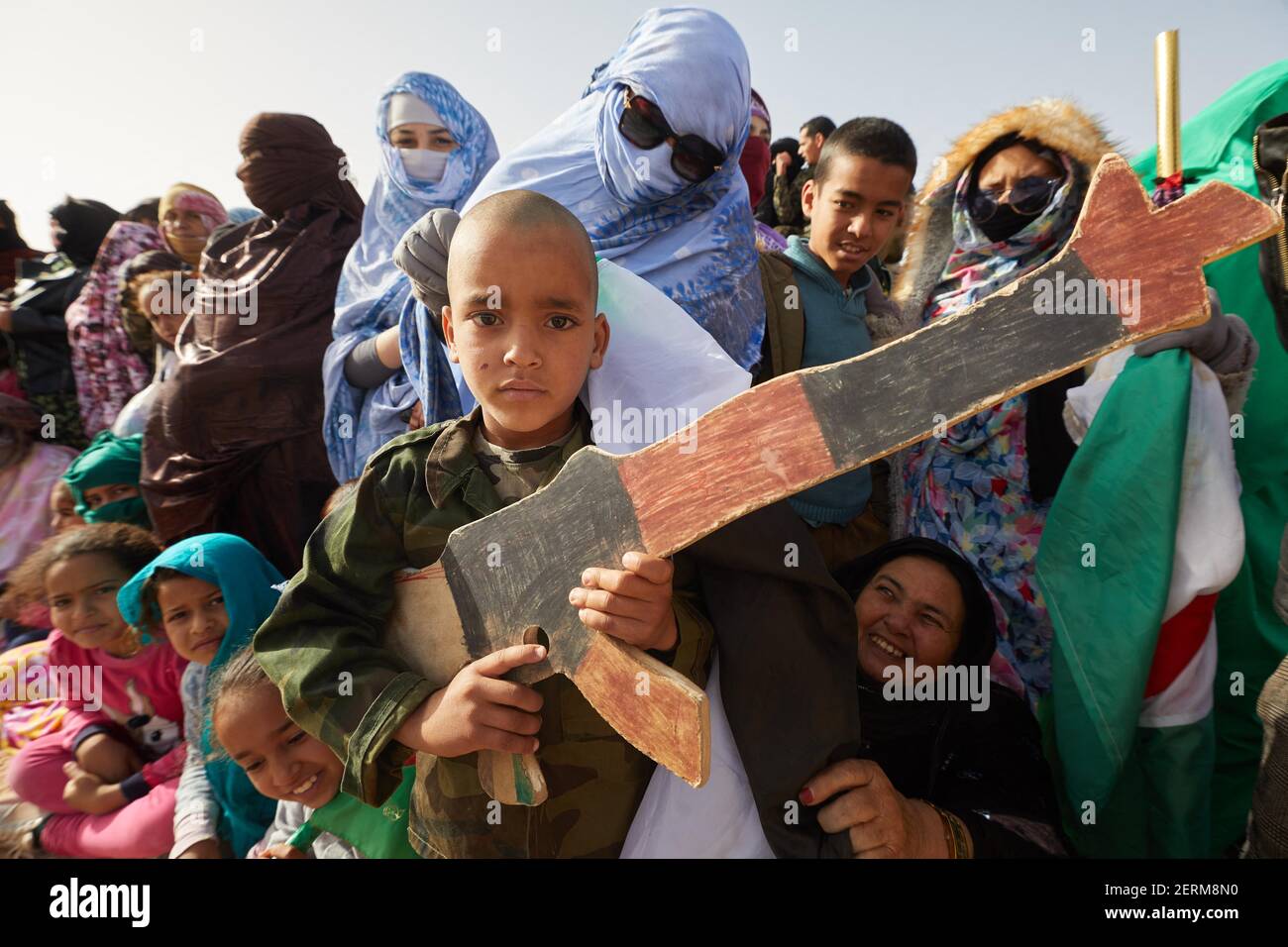 Sahrawis watch soldiers march in a parade during the celebrations ...