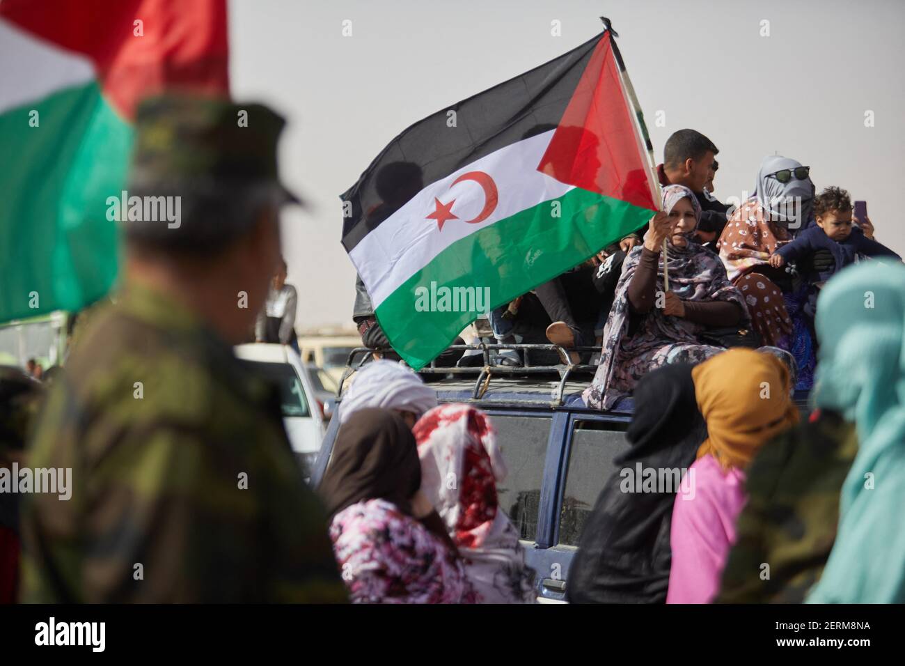 Sahrawis watch soldiers march in a parade during the celebrations ...