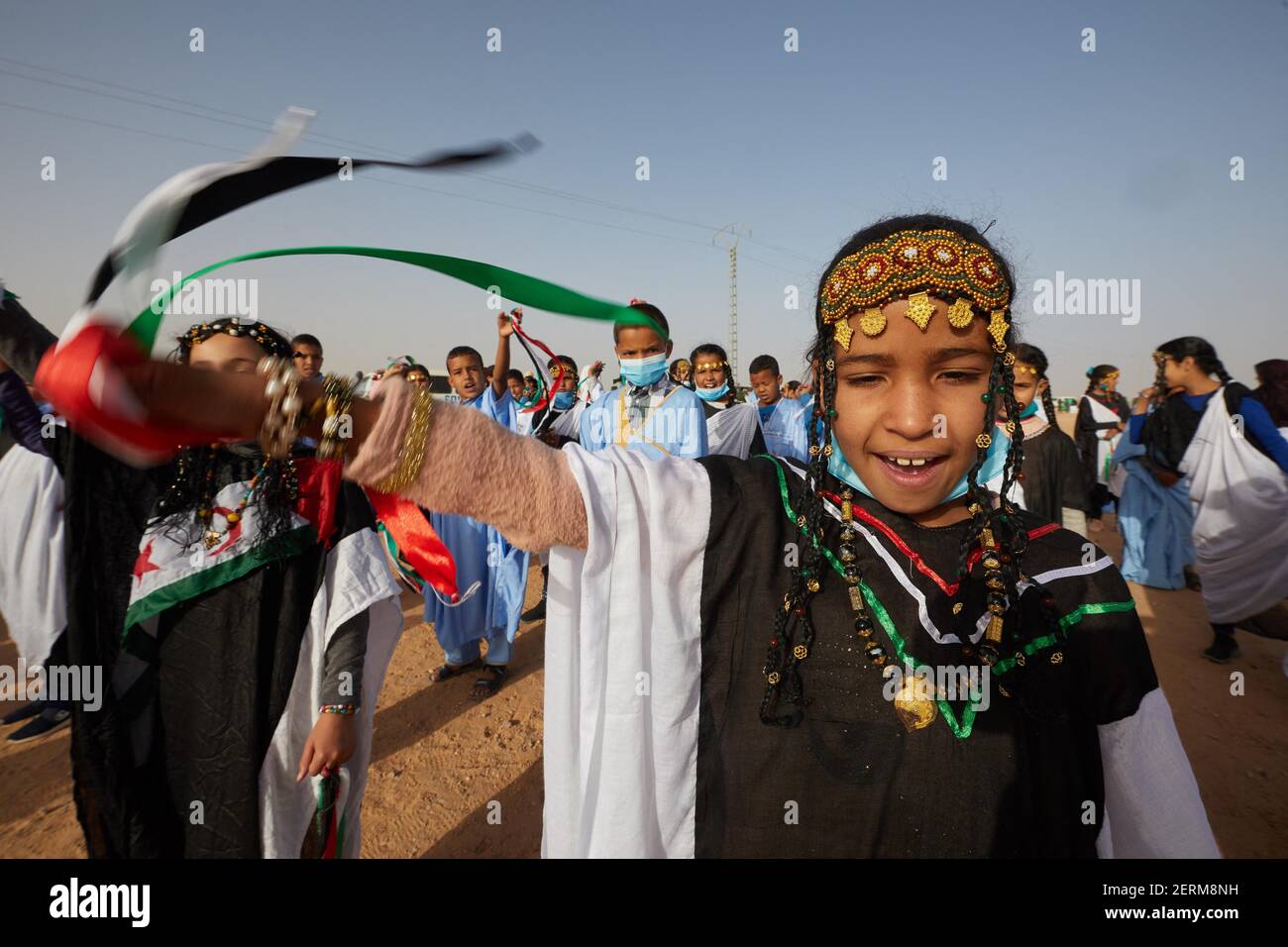 Sahrawis watch soldiers march in a parade during the celebrations ...