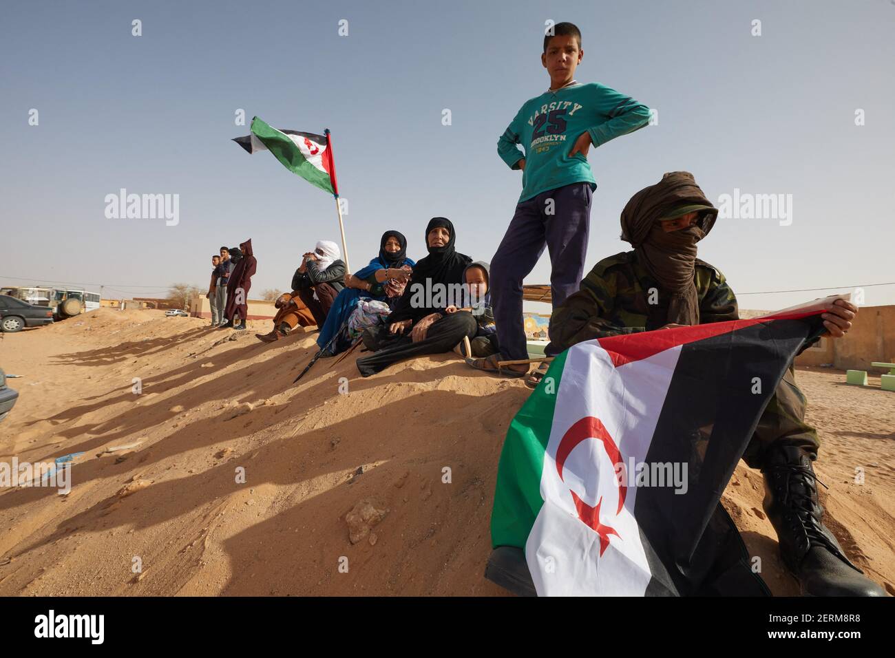 Sahrawis watch soldiers march in a parade during the celebrations ...