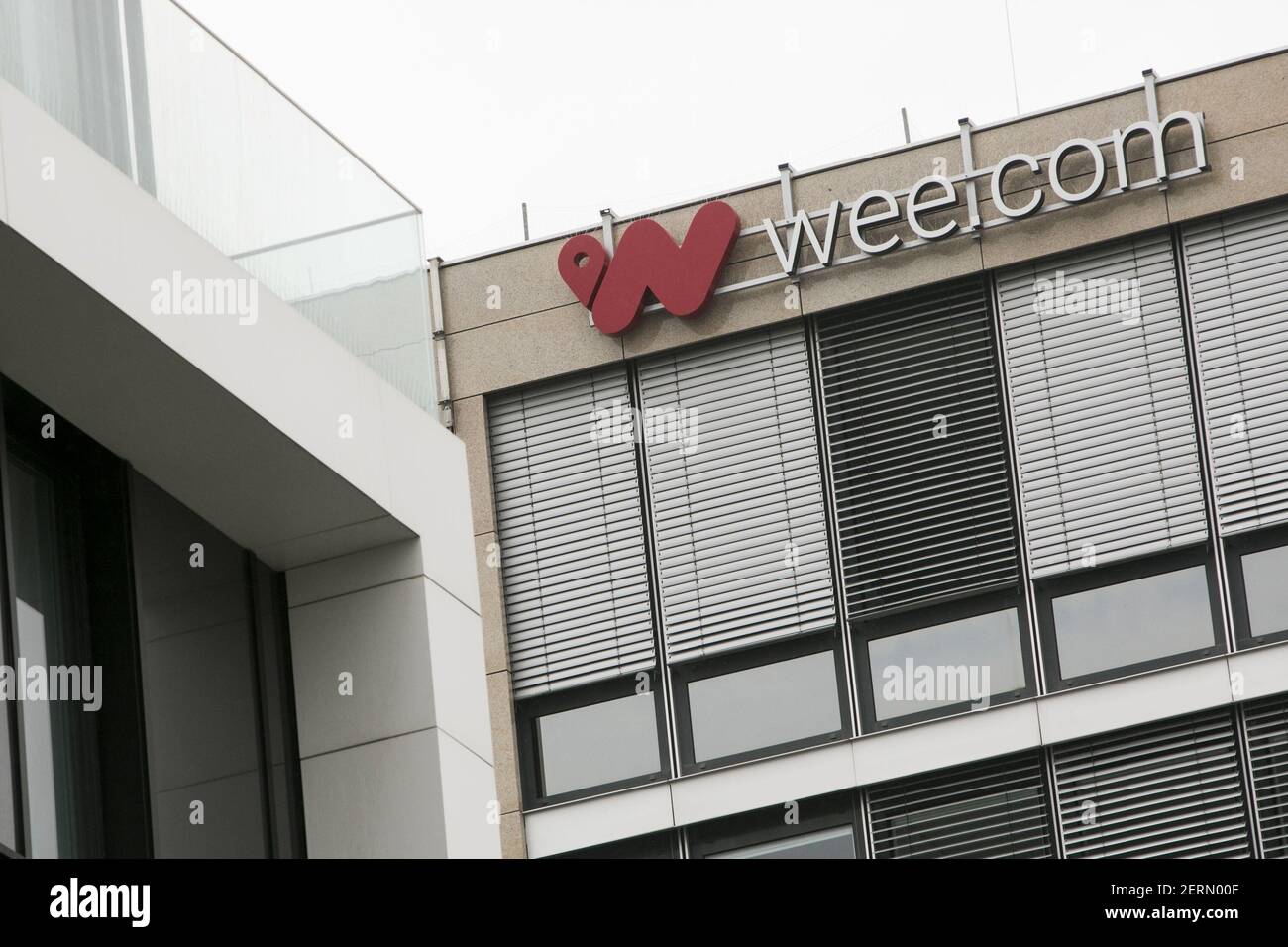 A logo sign outside of a facility occupied by Wee.Com AG in Munich ...