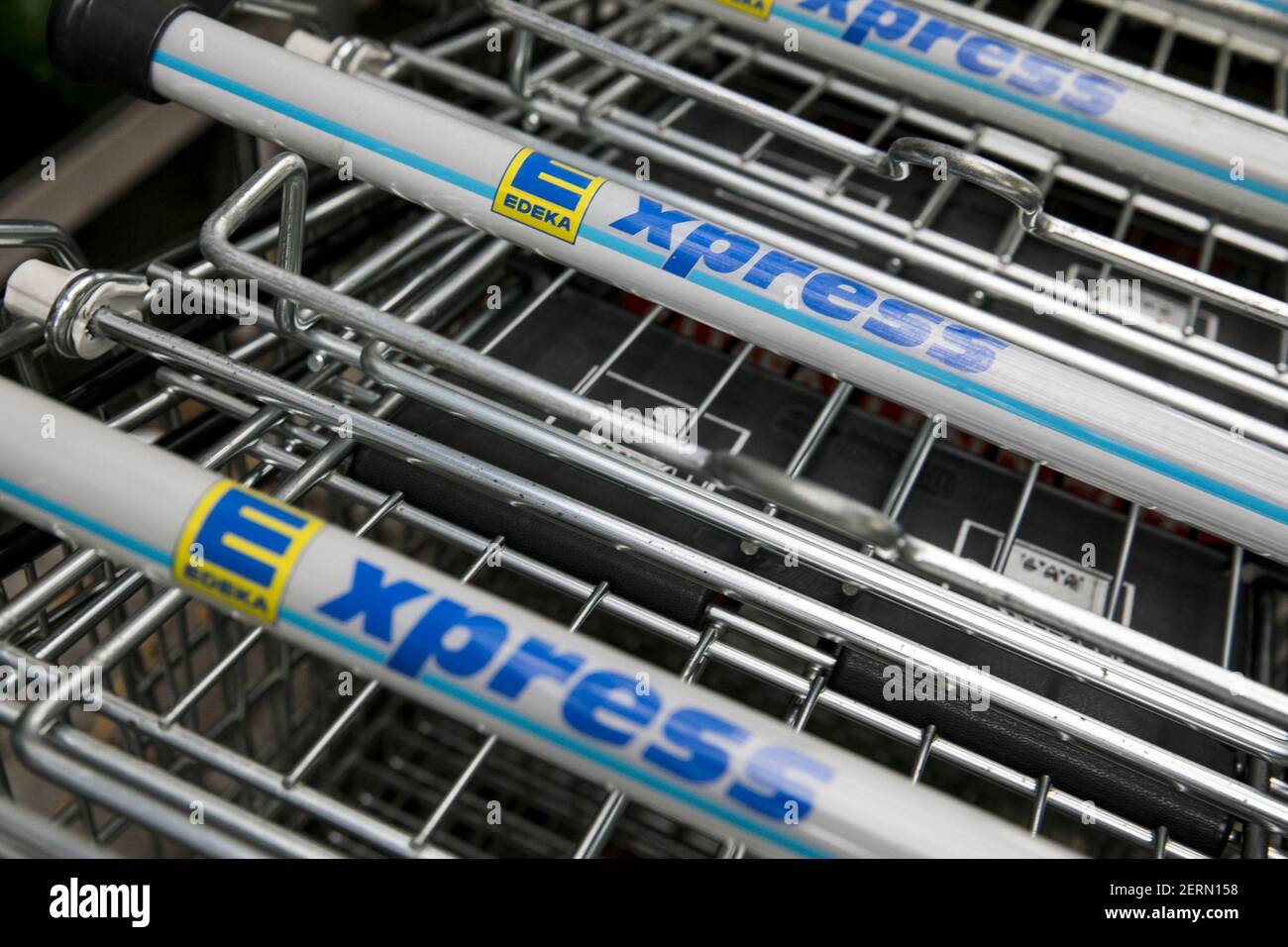 A logo sign outside of an Edeka Express retail grocery store in Munich ...
