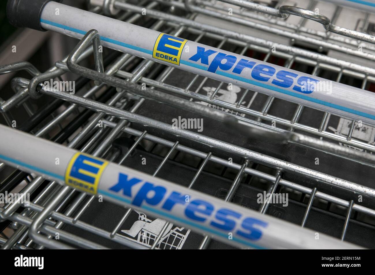 A logo sign outside of an Edeka Express retail grocery store in Munich ...
