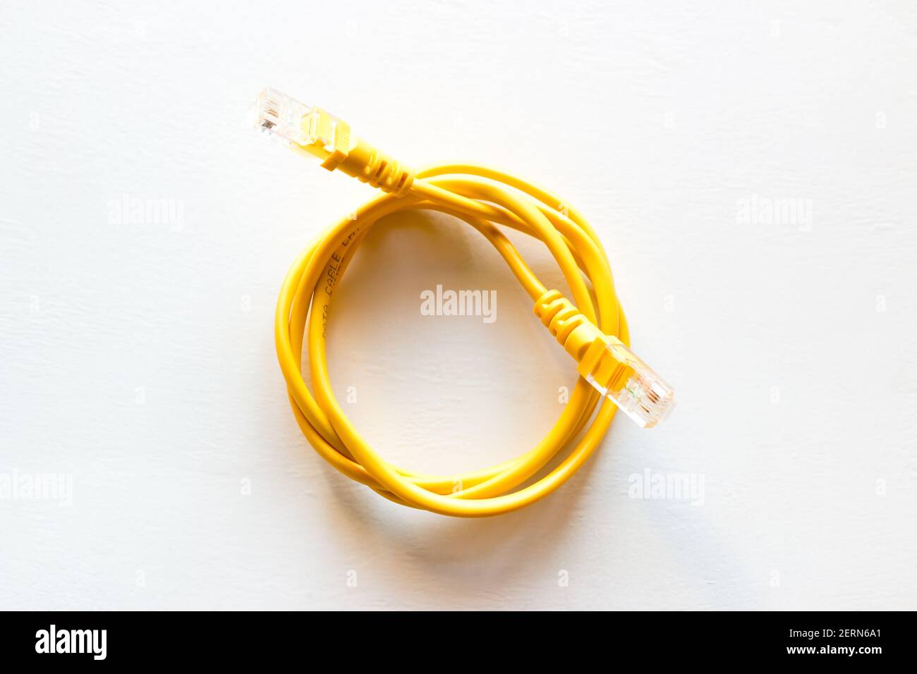 yellow lan internet cable on white background Stock Photo - Alamy