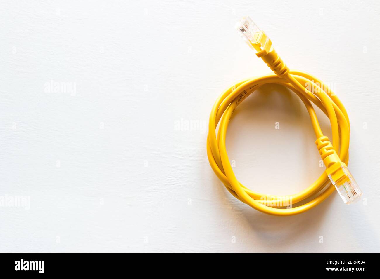 yellow lan internet cable on a white background with space for text ...