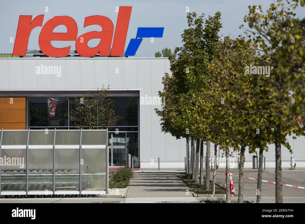 A logo sign outside of a Real (real,-) hypermarket retail store in ...