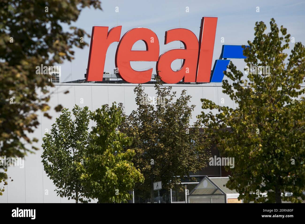 A logo sign outside of a Real (real,-) hypermarket retail store in ...