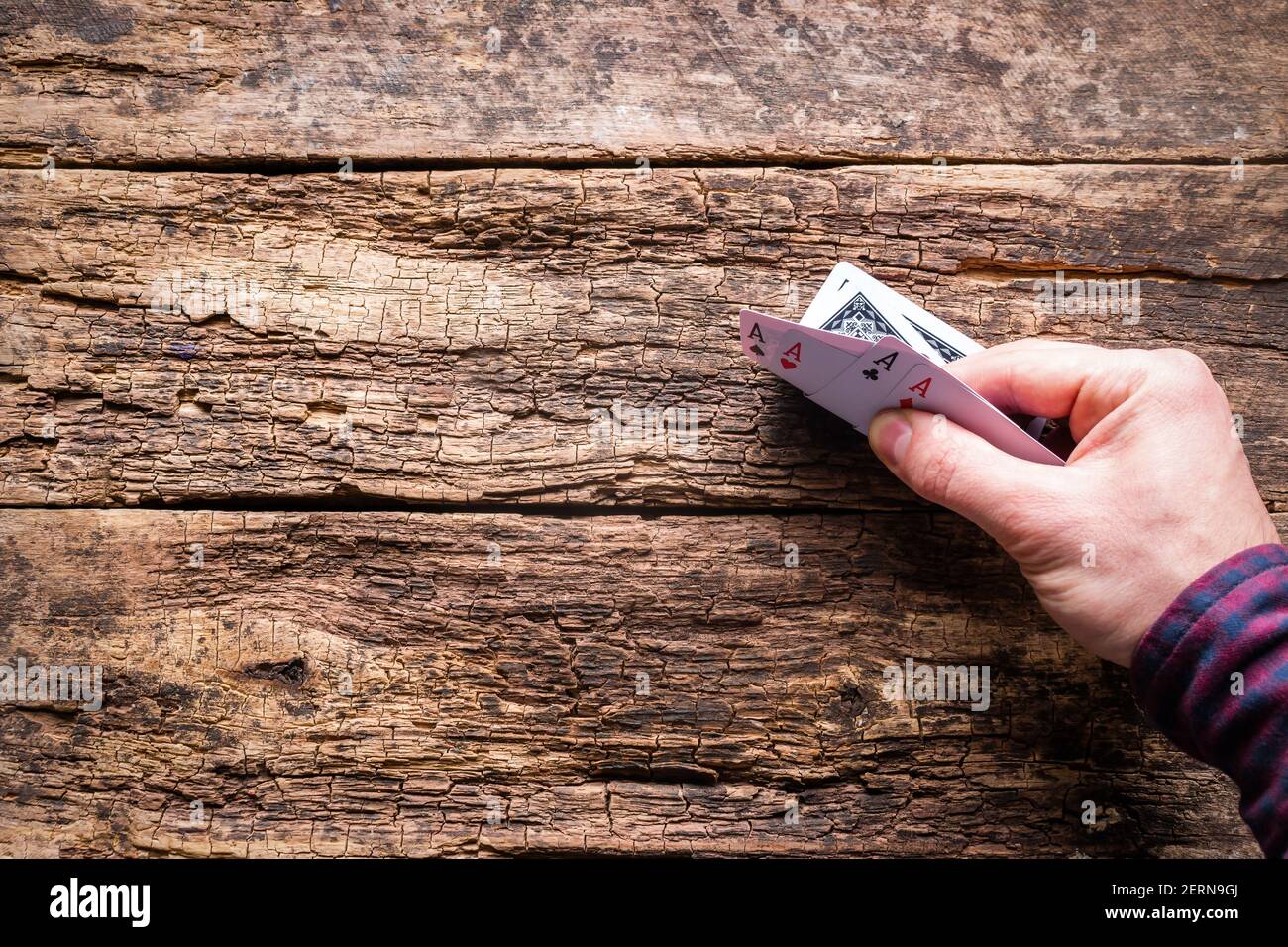 card player looks at his cards on a wooden background with space for ...