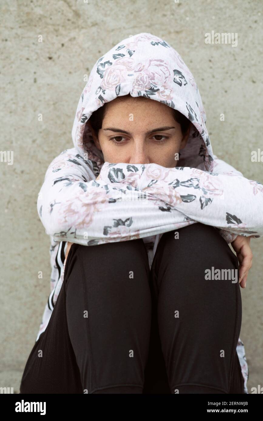 Scared hooded woman looking away Stock Photo - Alamy