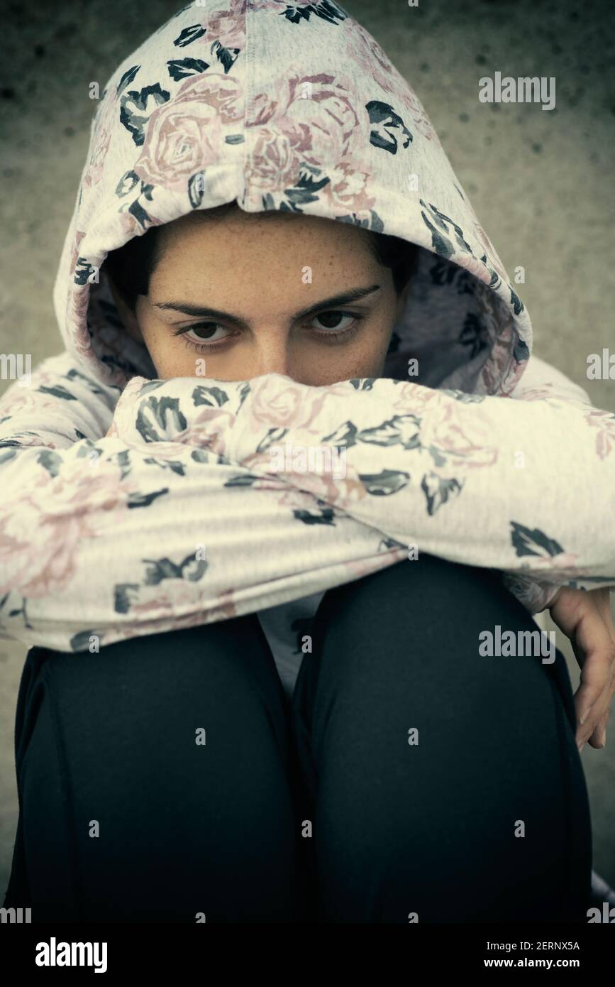 Scared hooded woman looking away Stock Photo - Alamy