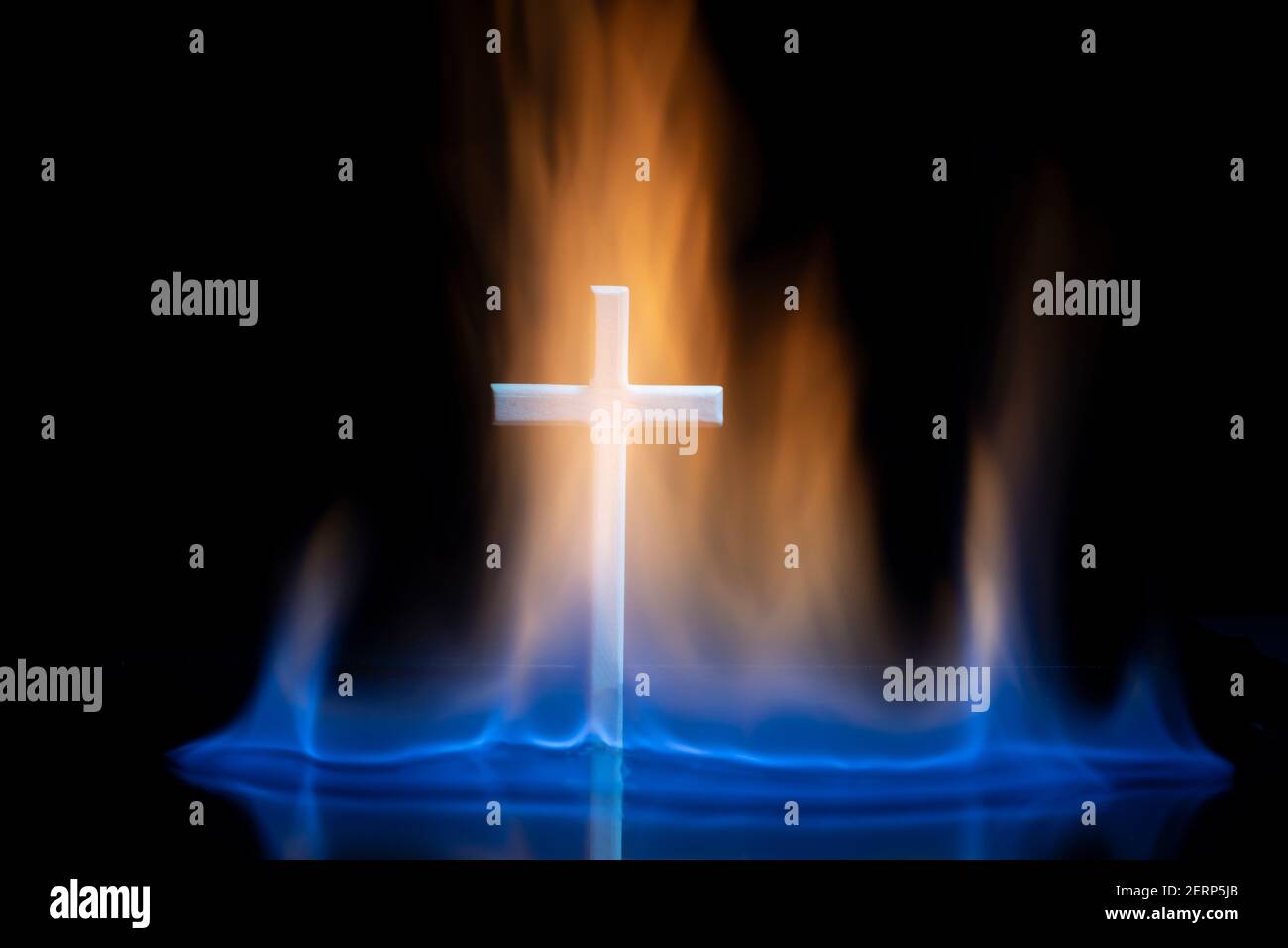 Cross or crucifix surrounded by burning fire flames. Religious theme ...