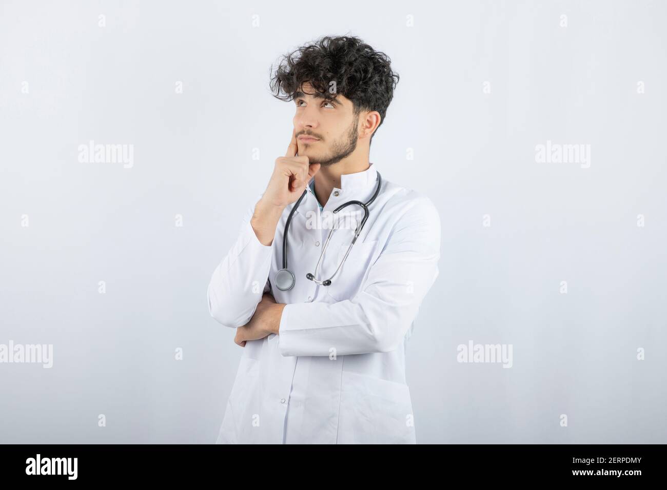 Portrait of a confident male doctor looking up isolated on white ...
