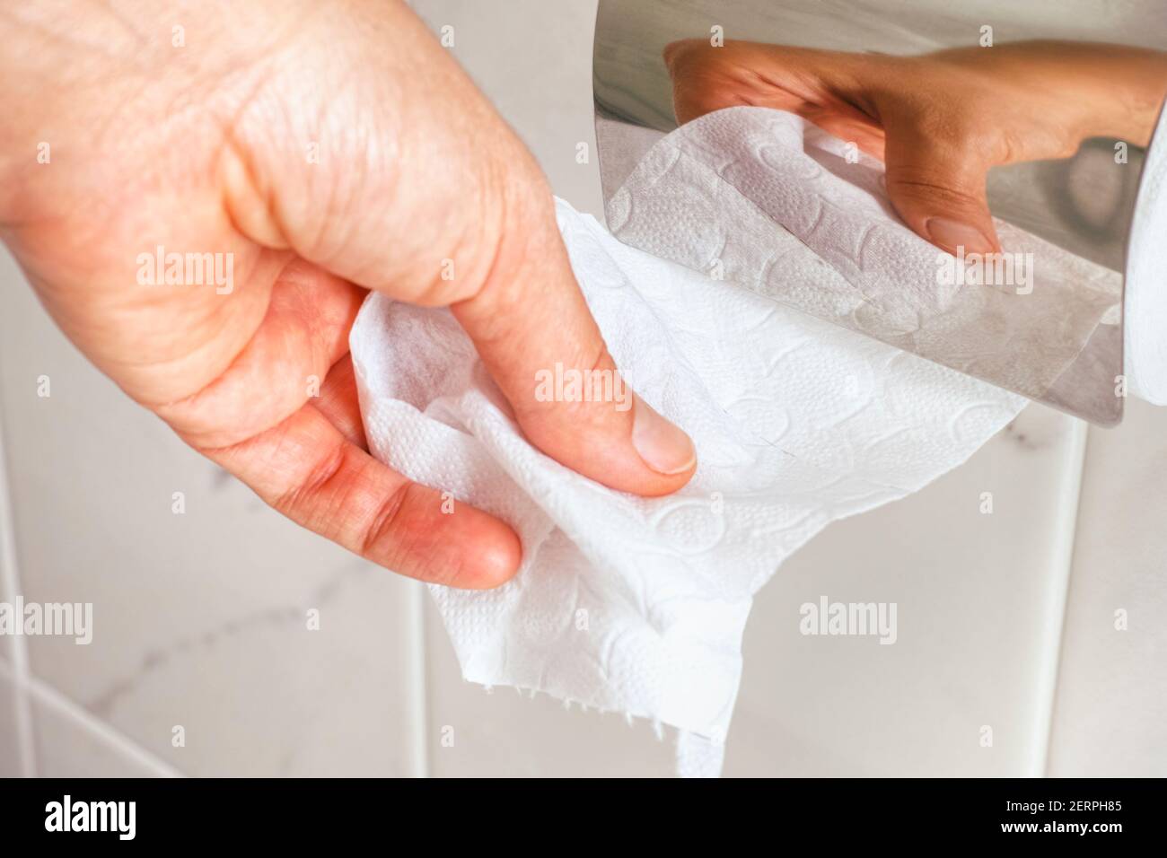 Person taking toilet paper from a toilet paper roll. Close-up Stock ...