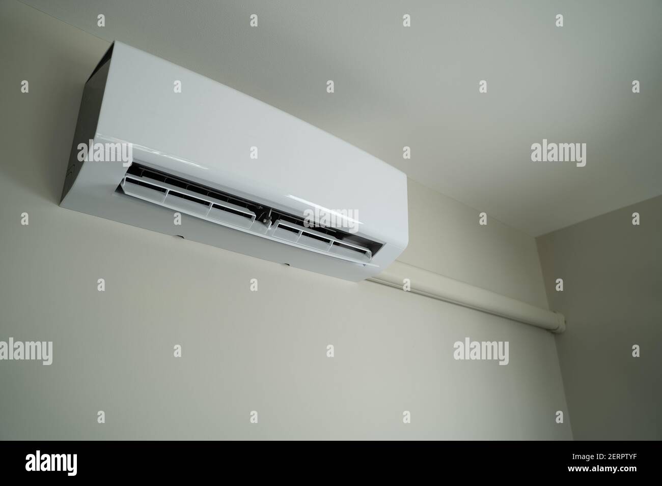 Air conditioner inside top the room man operating remote controller ...