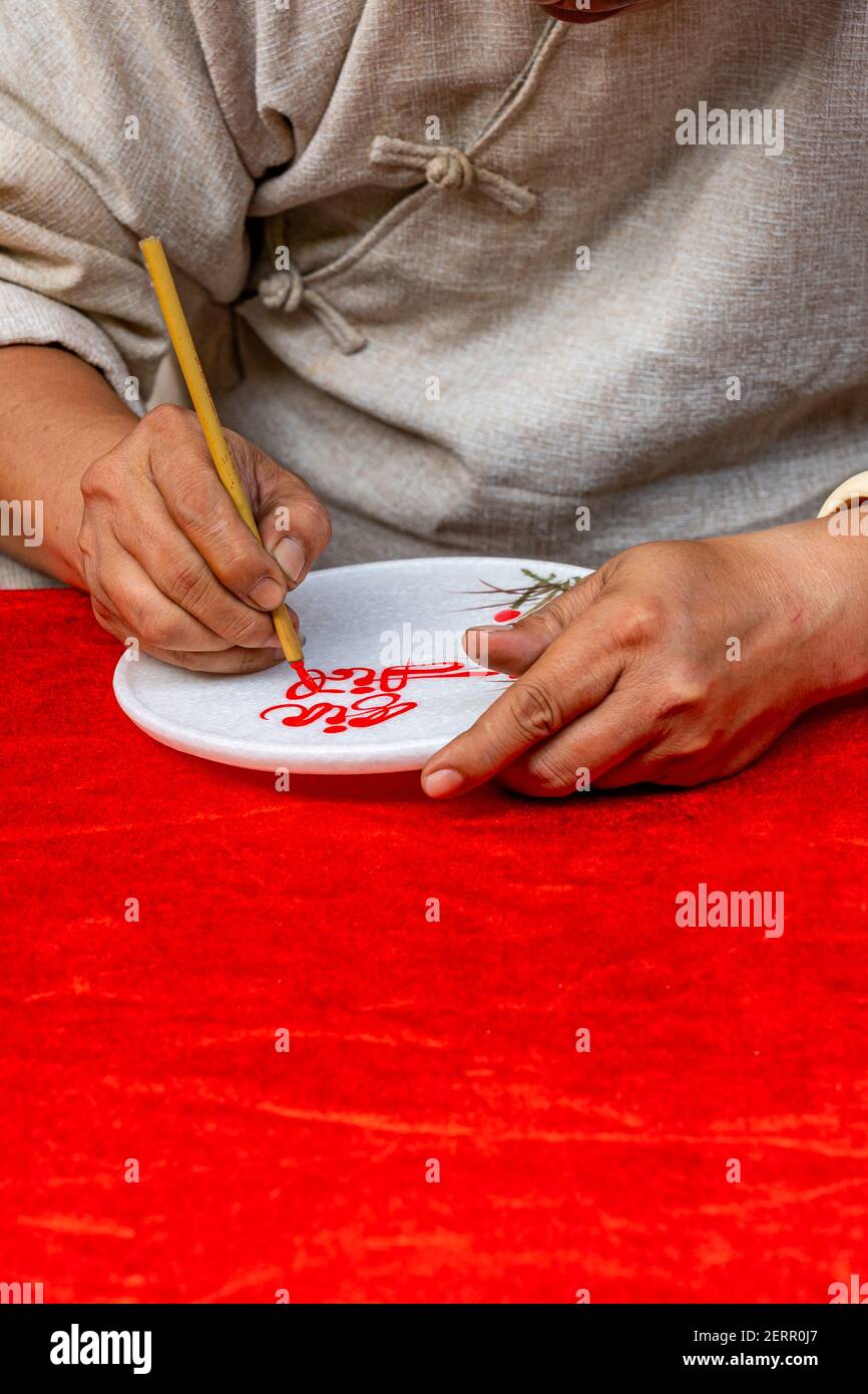 Vertical photo of human hand doing handwriting by calligraphic brush ...