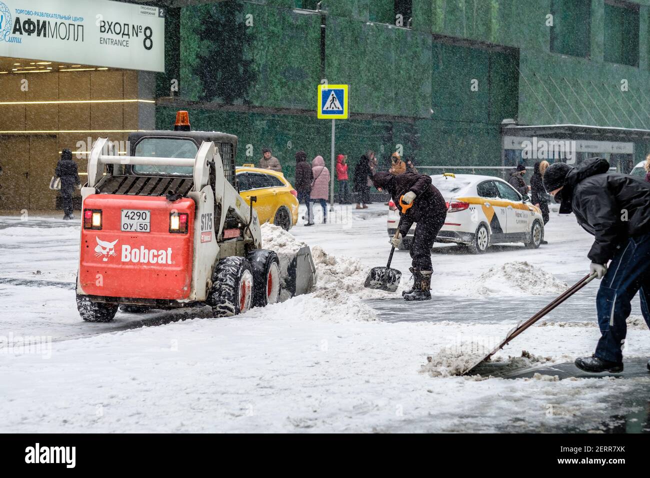 Moscow. Russia. February 12, 2021. Several utility workers with shovels ...