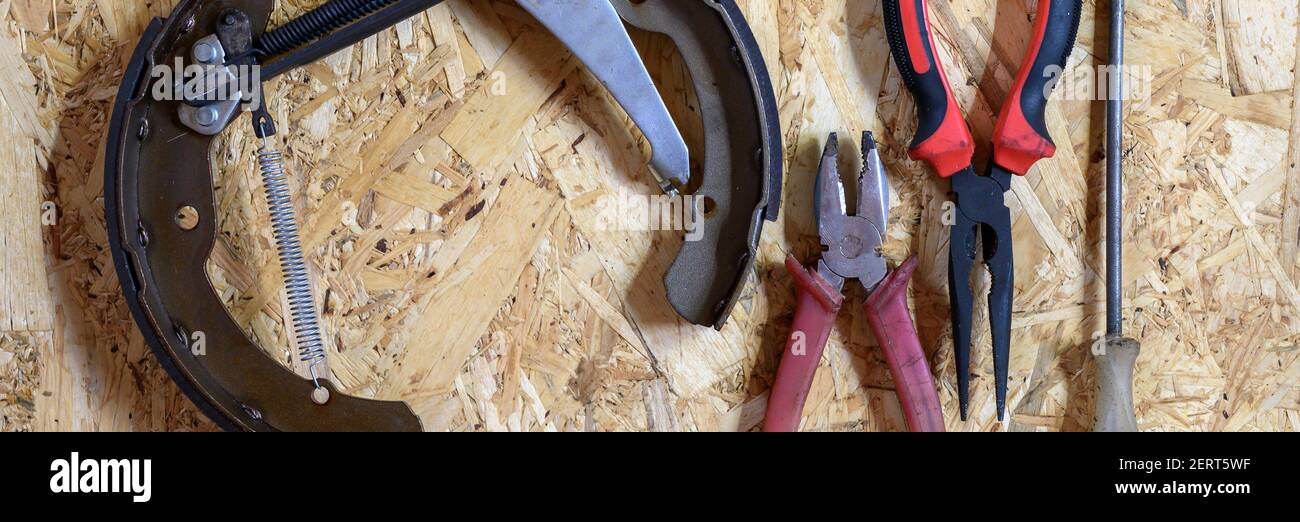 car drum brake disassembled and a set of various repair hand tools or ...