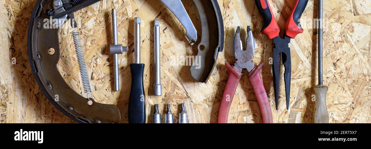 car drum brake disassembled and a set of various repair hand tools or ...
