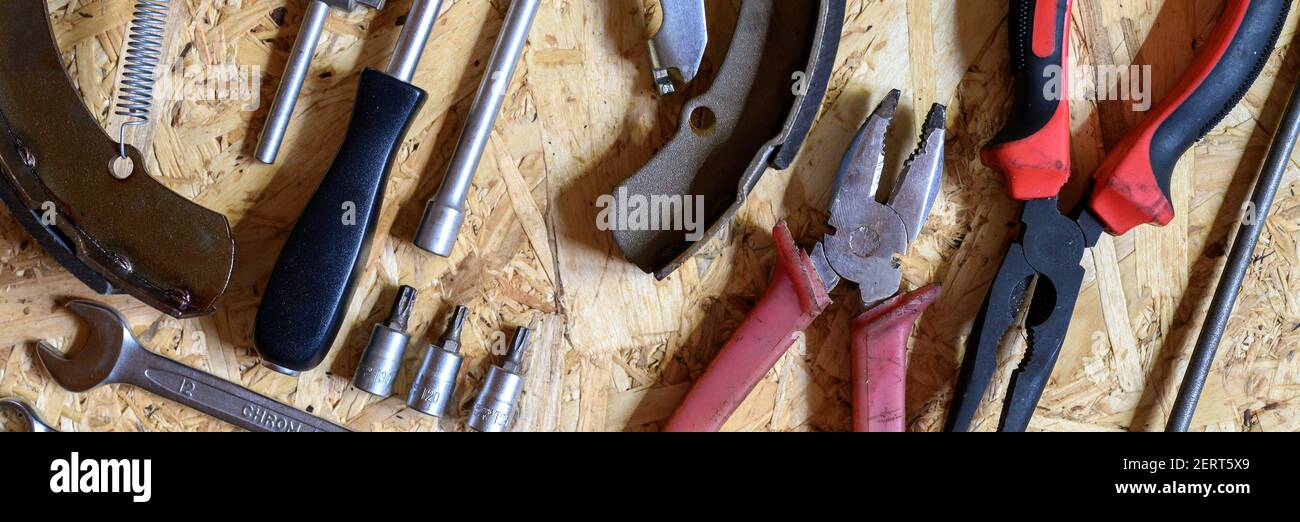 car drum brake disassembled and a set of various repair hand tools or ...