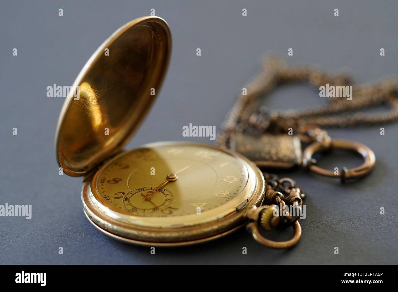 Old gold-plated pocket watch in close-up with dark background Stock ...