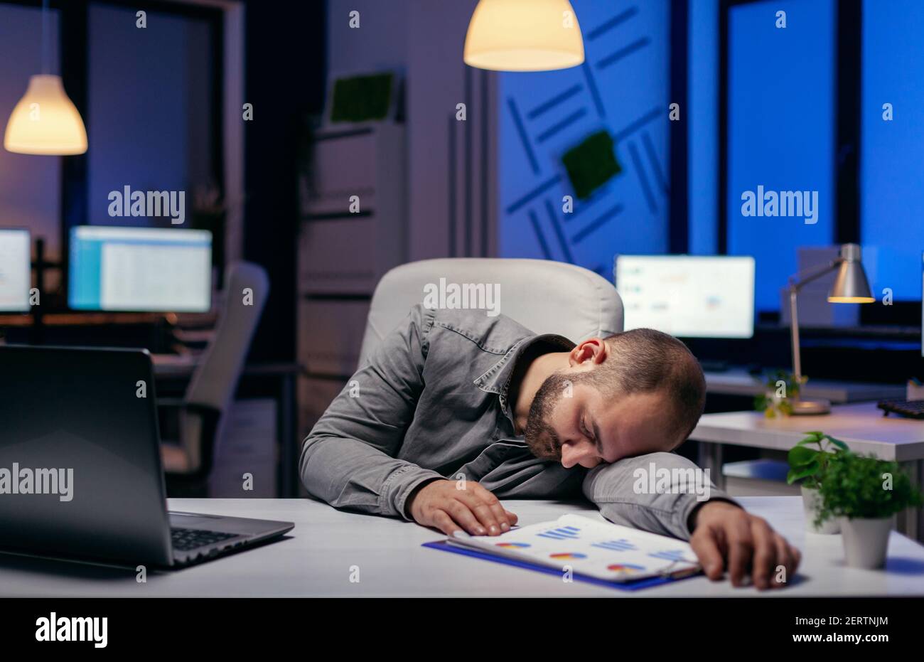 Tired businessman sleeping in his workplace on desk. Workaholic ...