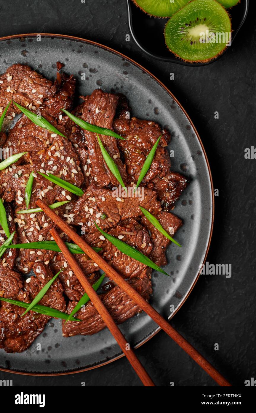 Beef Bulgogi on black plate on dark slate table top. Korean cuisine ...