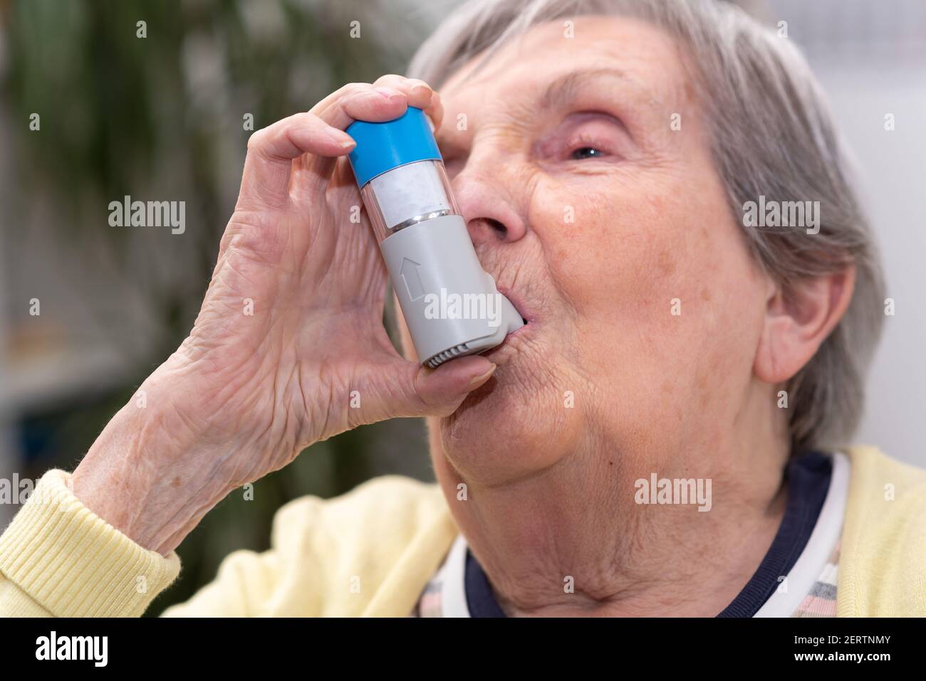 Elderly woman using an asthma inhaler Stock Photo - Alamy