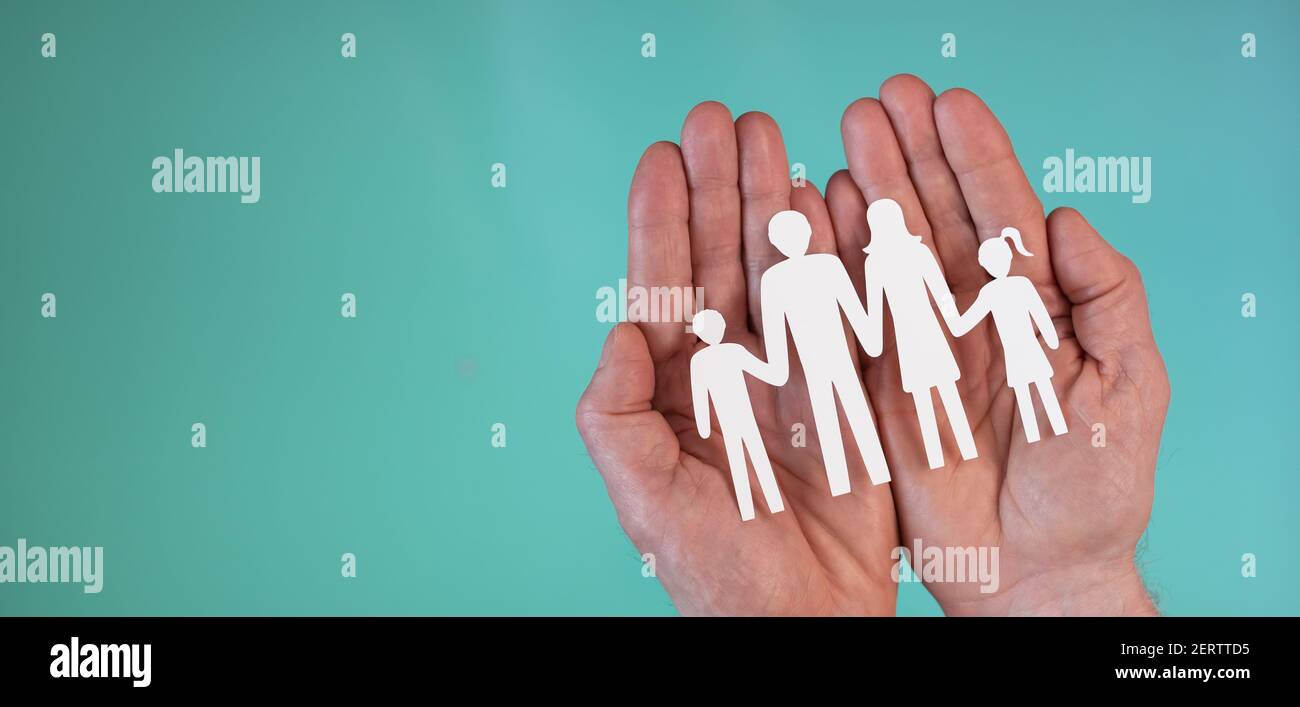 Concept of family insurance with paper family in hands on turquoise ...