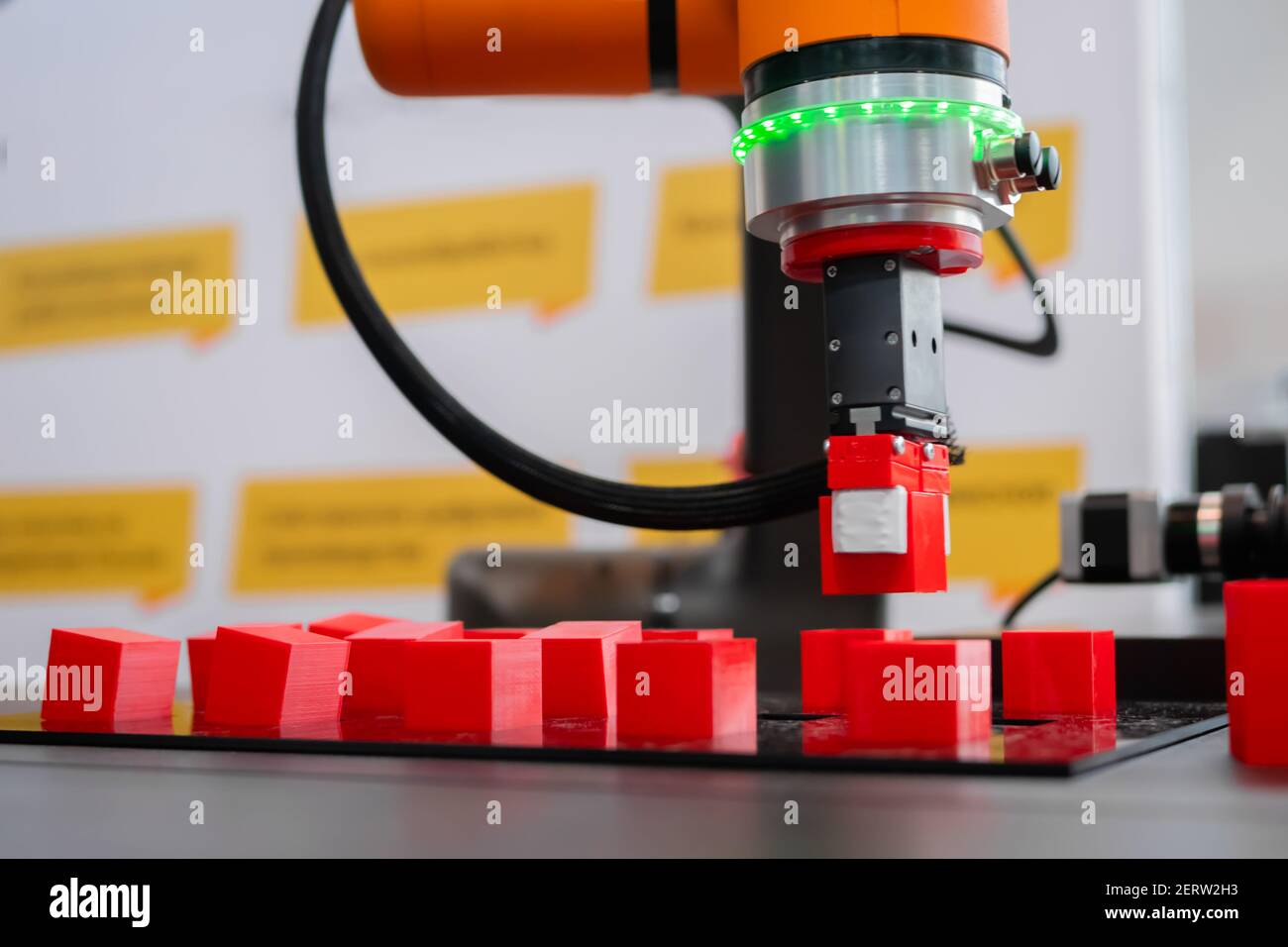 Pick and place robotic arm manipulator moving red toy blocks at robot ...