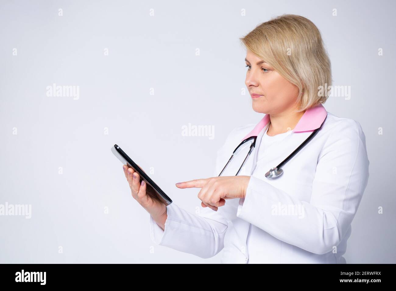 Side view of a nurse or doctor uses a digital tablet, forefinger to ...