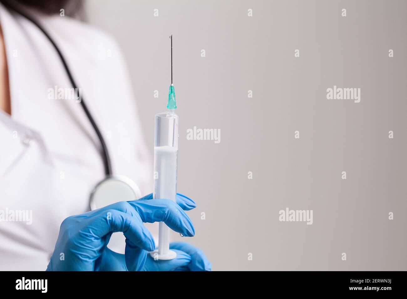 Woman holding medical injection syringe in her outstretched hand ...