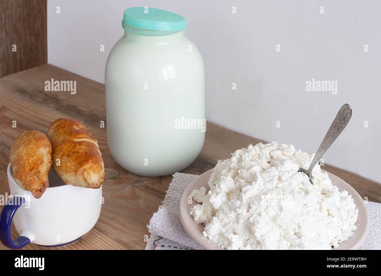 Rustic breakfast: milk, cottage cheese and pies Stock Photo - Alamy