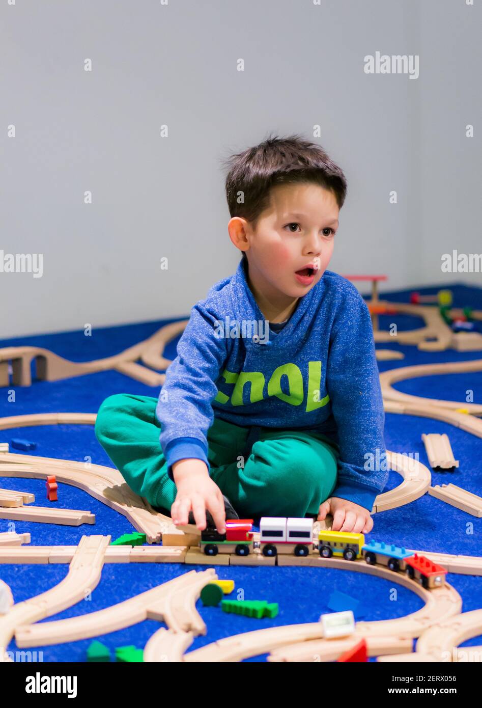 POZNAN, POLAND - Jan 27, 2018: Boy sitting with a wooden toy train set on a Kolejkoland model ...