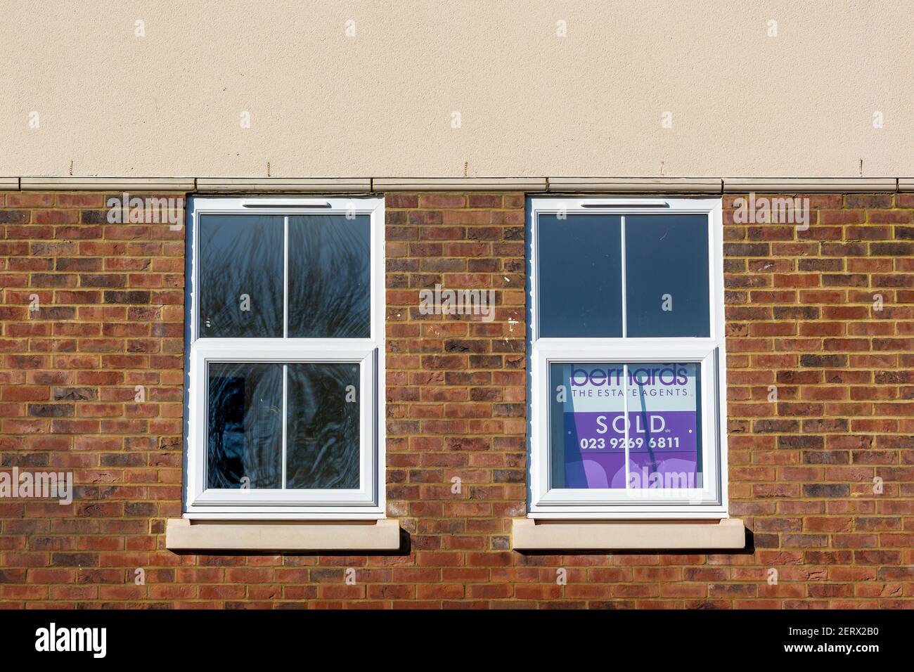 An estate agent sold sign in the window of new apartments or flats ...