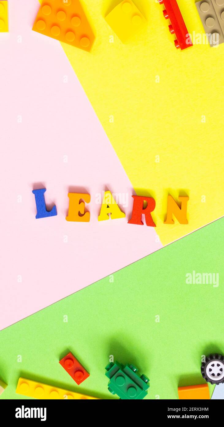 The word "LEARN" is made of colored wooden letters on a multicolored ...