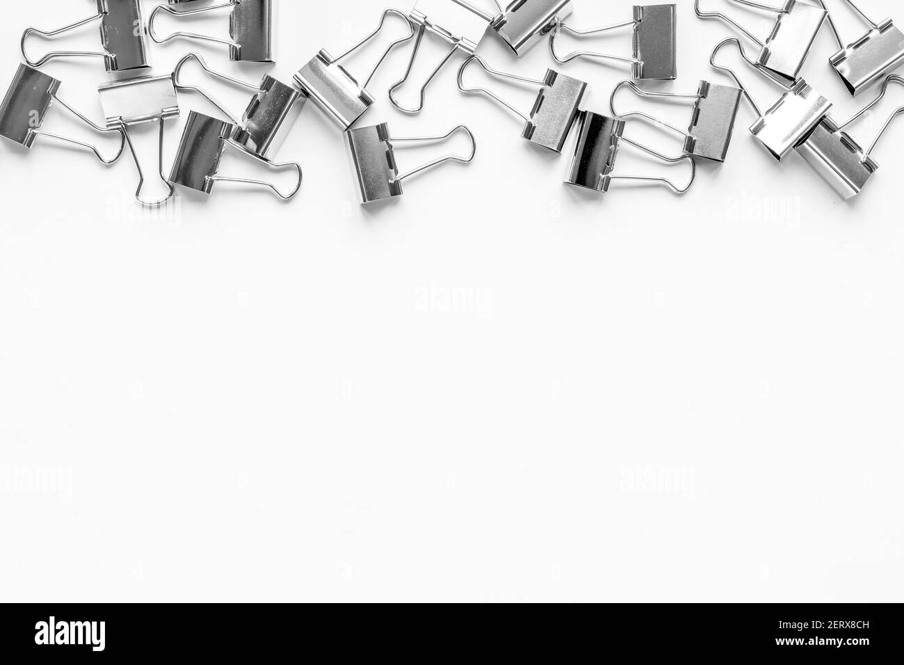 Stationery and office supplies background. Paper binder clips top view ...