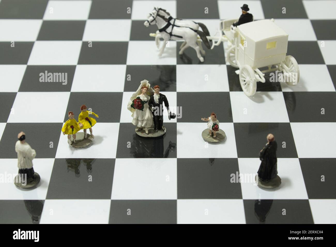 The miniature toy pieces around a bride and a groom piece on a ...