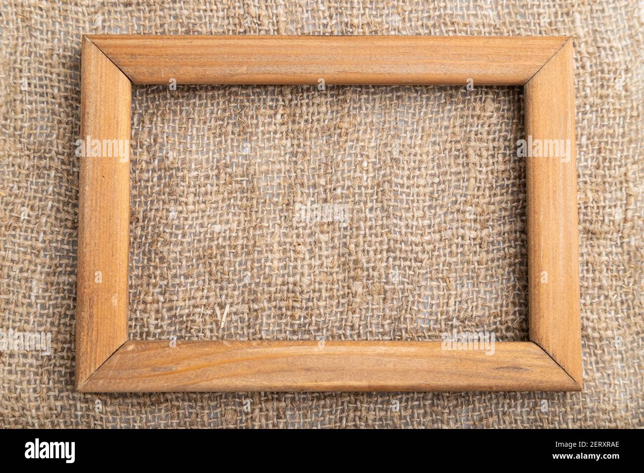 Wooden frame on smooth brown linen tissue. Top view, flat lay, natural ...
