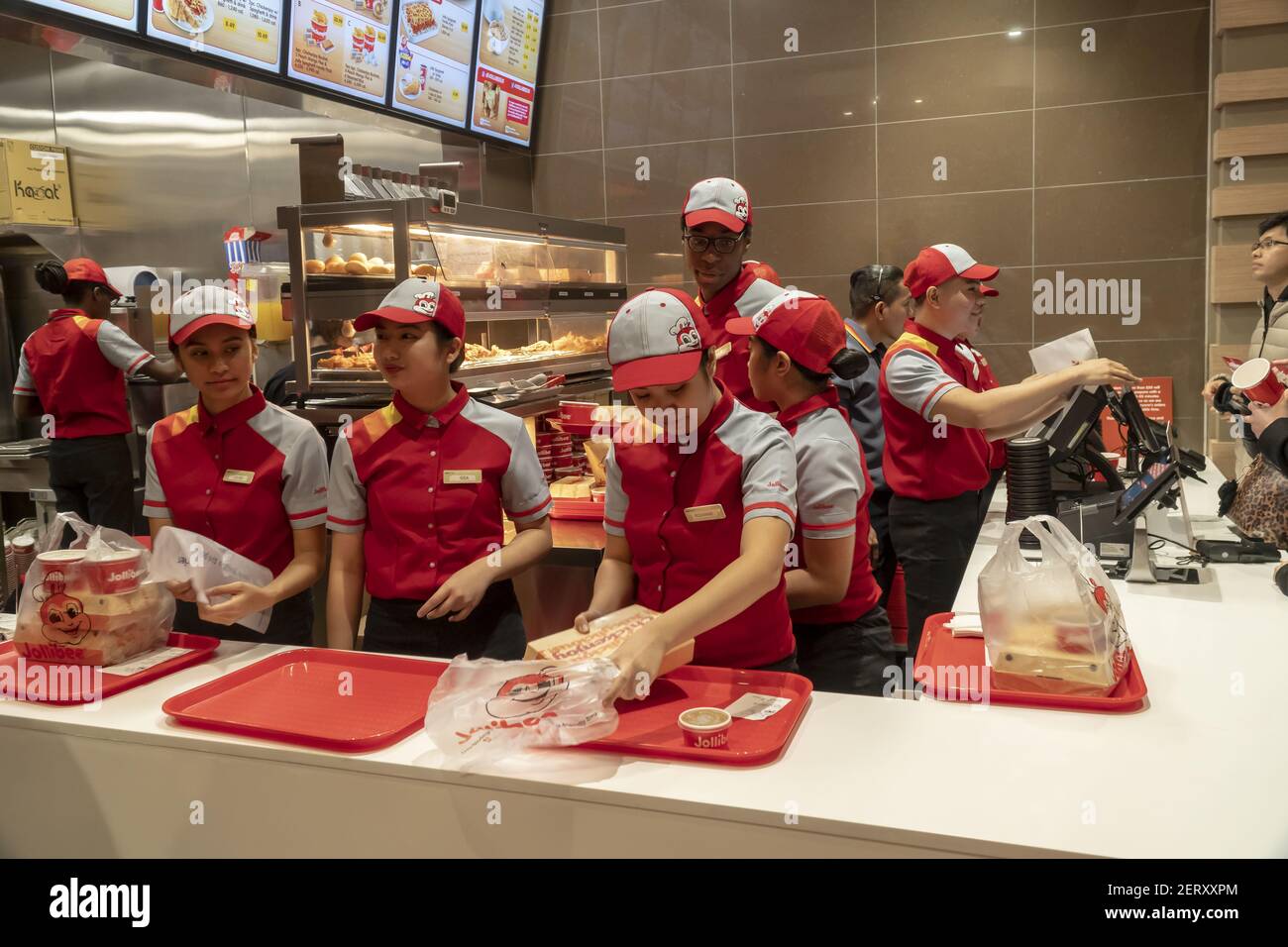 Workers hurry to prepare orders in the Jollibee fast food restaurant in ...