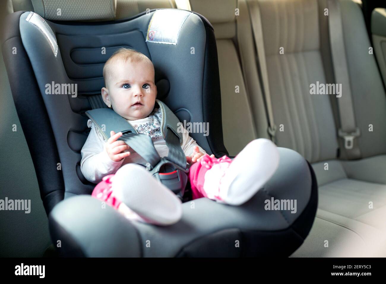 Adorable little baby girl getting bored of the road trip and driving ...