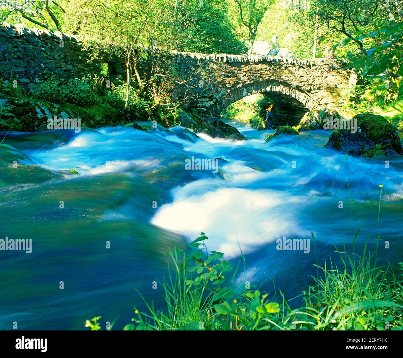fast flowing river, and stone bridge Stock Photo - Alamy
