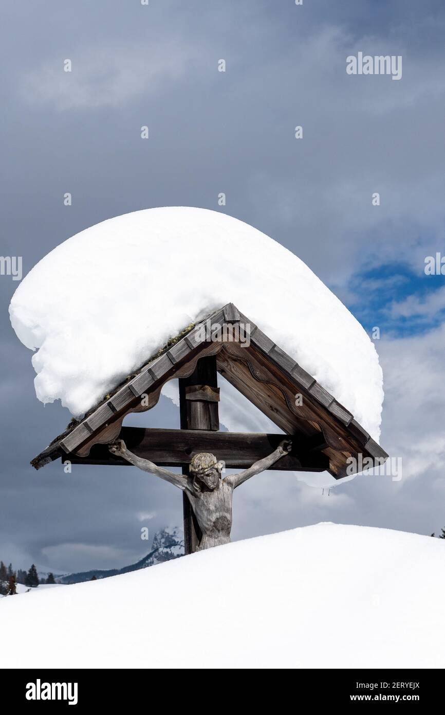 A statue crucifixion of Jesus Christ under a snow-covered roof Stock Photo - Alamy