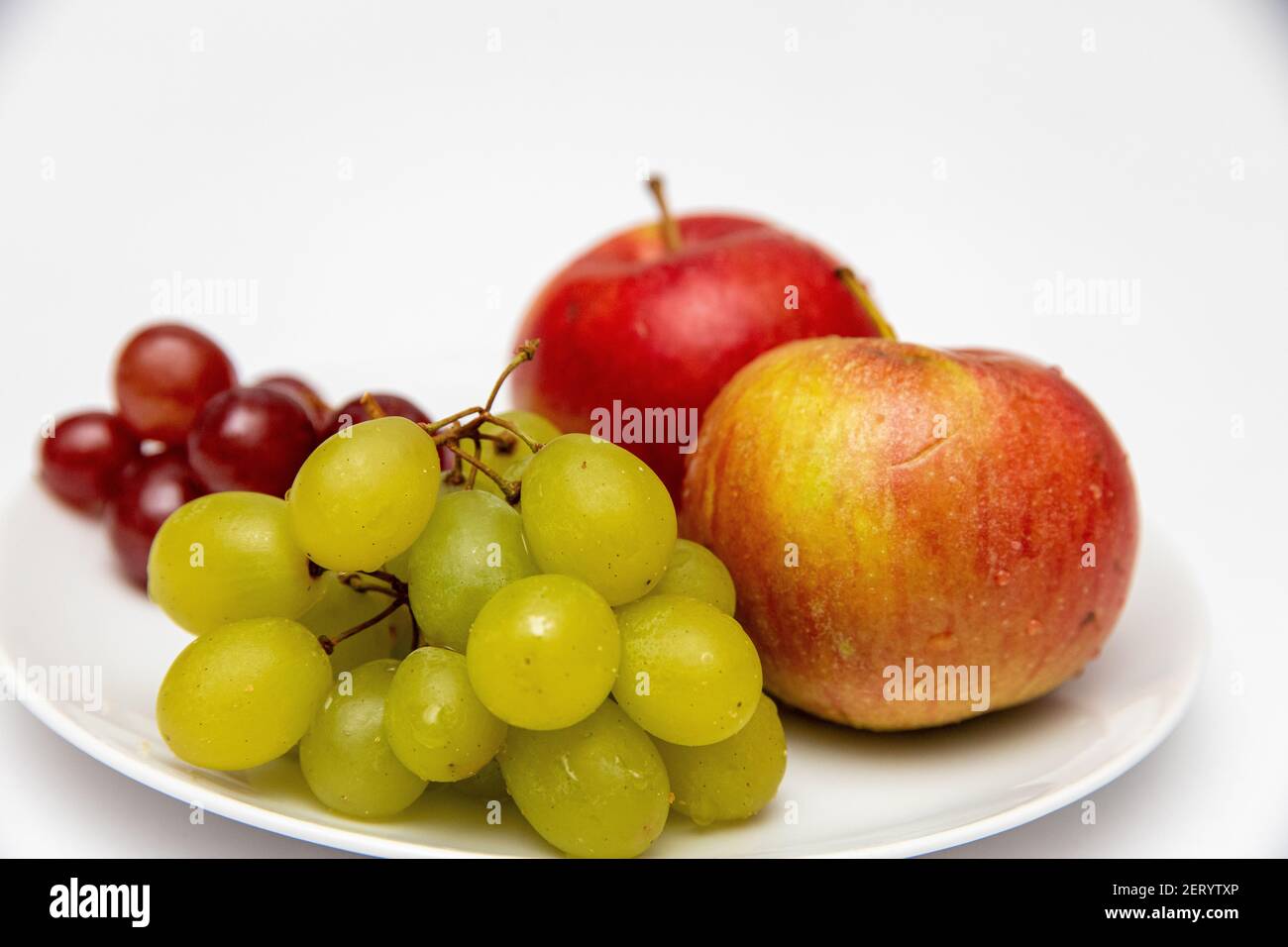 Two apples and ripe fresh grapes in a plate on a white background Stock ...