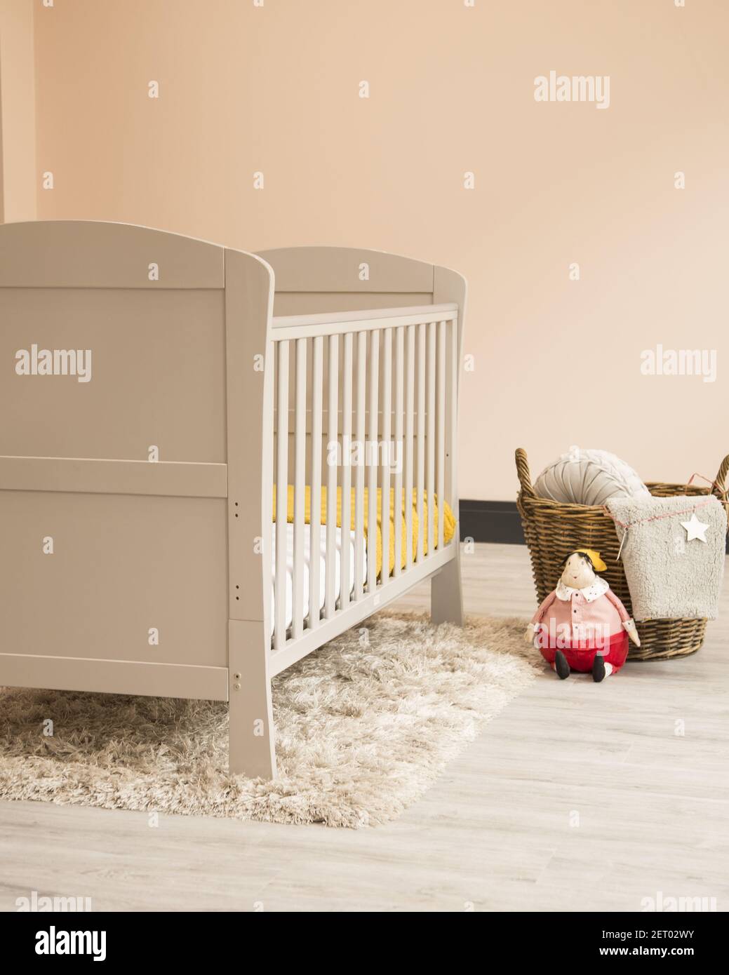 A wooden crib, straw basket and a toy in a chi Stock Photo - Alamy