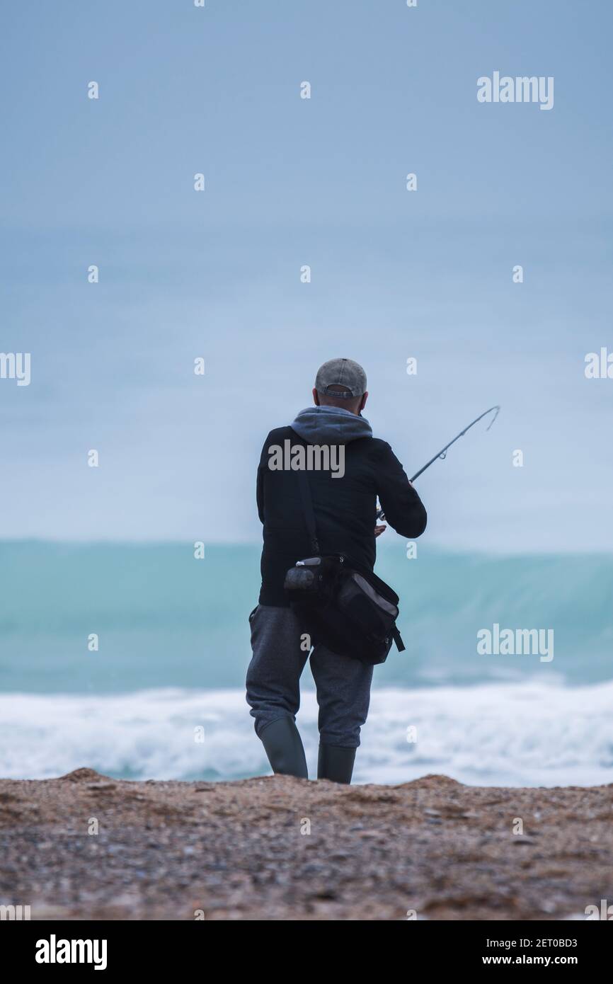 Angler enjoying his hobby at the beach Stock Photo - Alamy